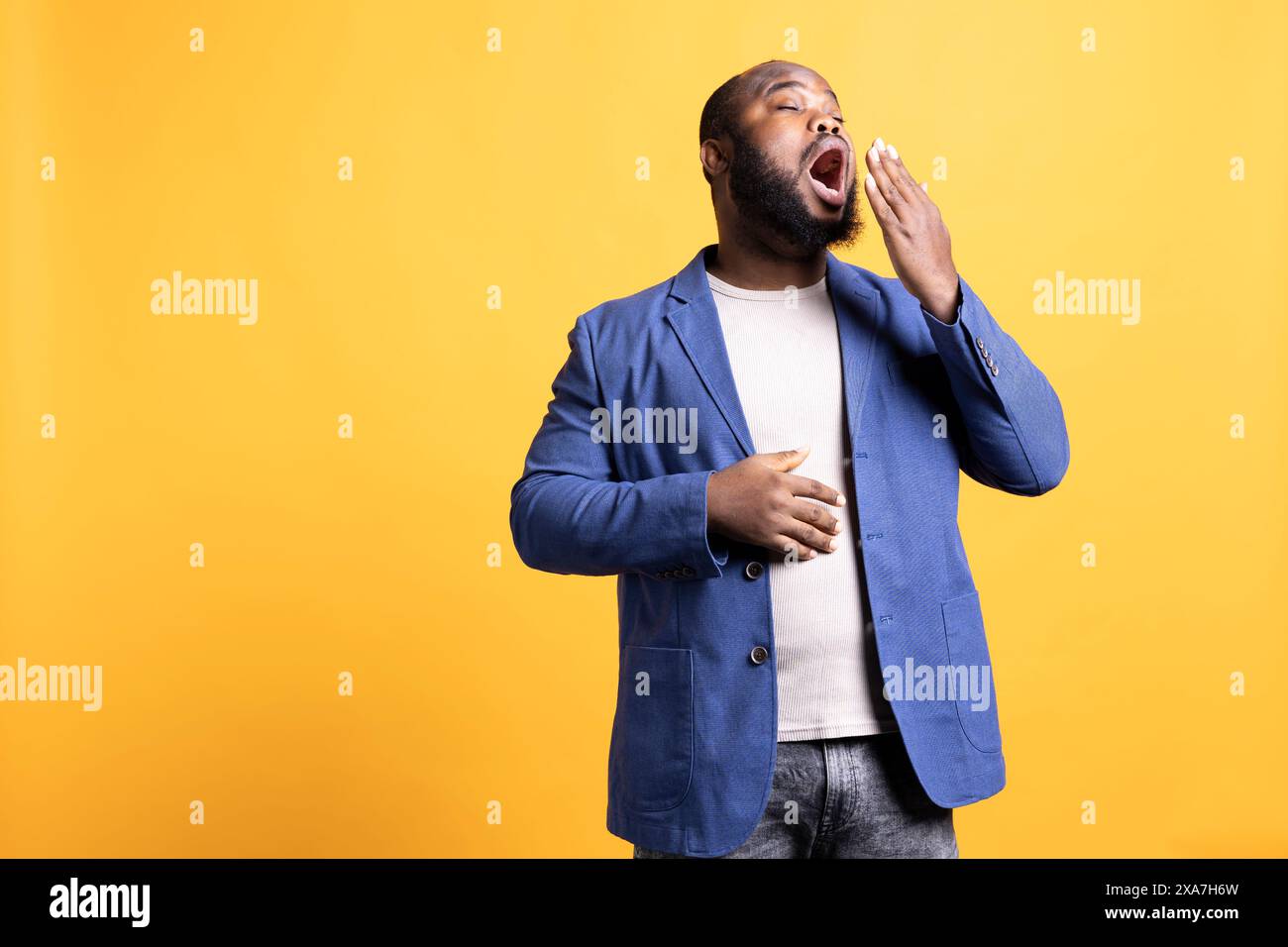 African american man feeling exhausted and yawning, covering his mouth ...