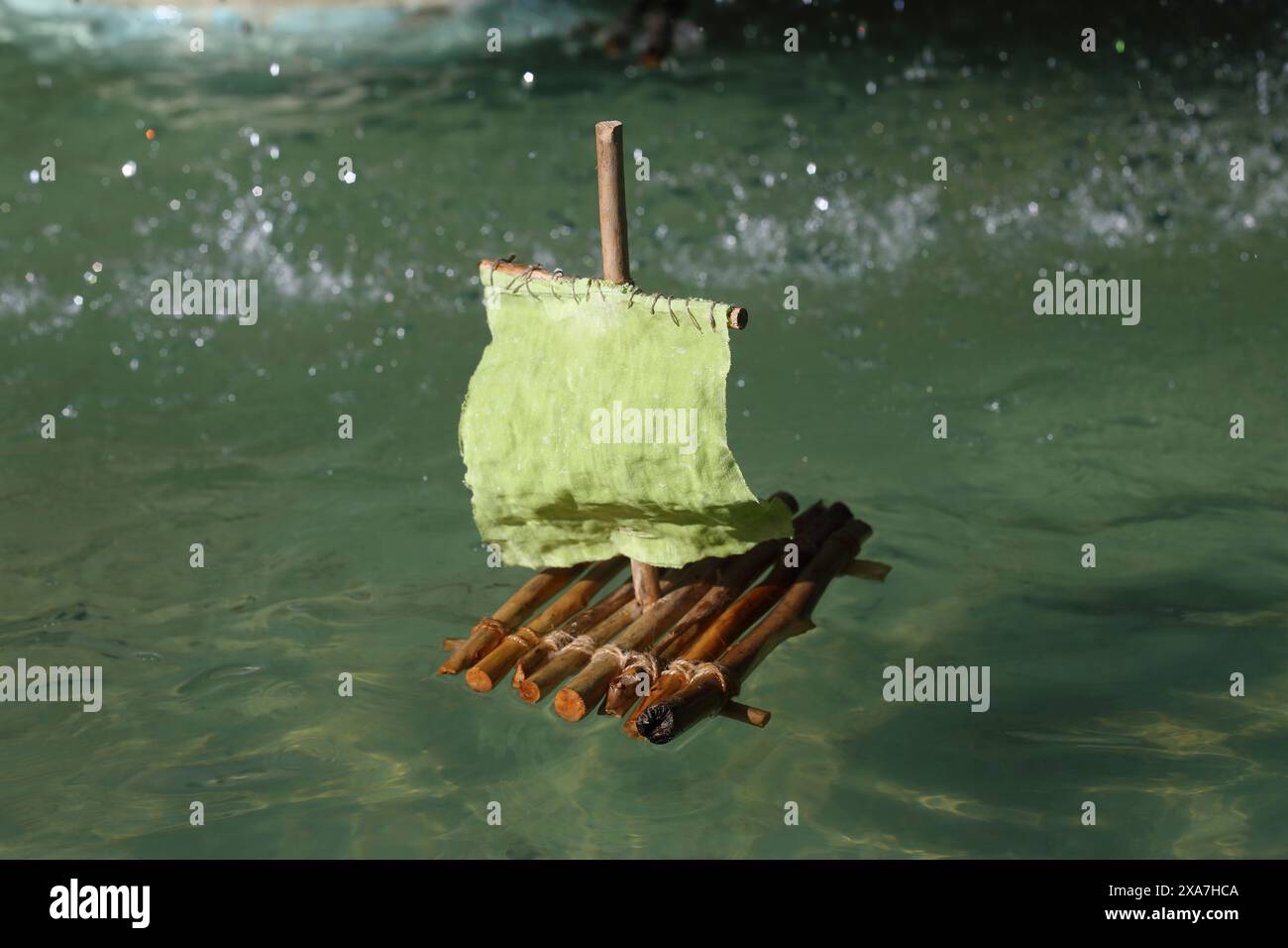 model of wooden raft in green waters Stock Photo - Alamy