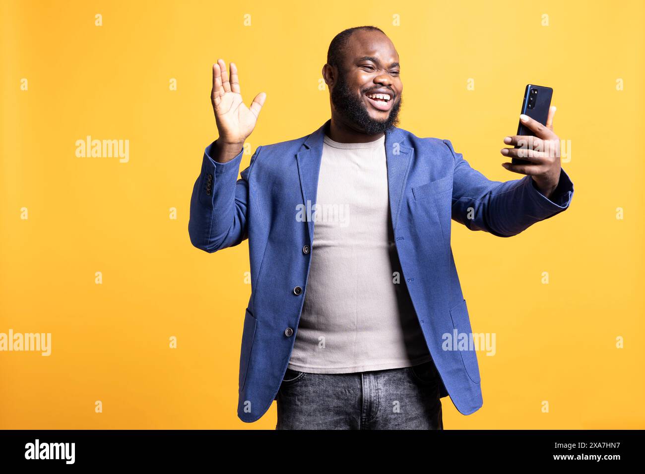 Cheerful man excited to greet friends during teleconference meeting ...