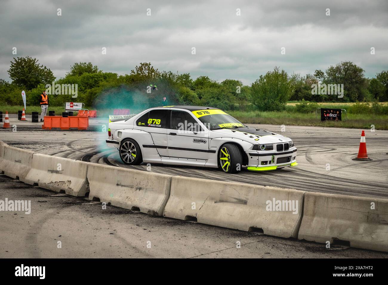 A car on a racing track emitting smoke from the engine Stock Photo - Alamy