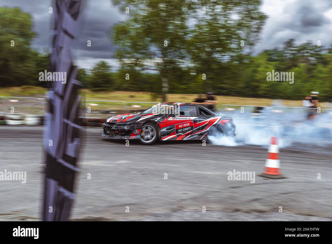 A Person driving a red, white, and black race car on a speedway track ...