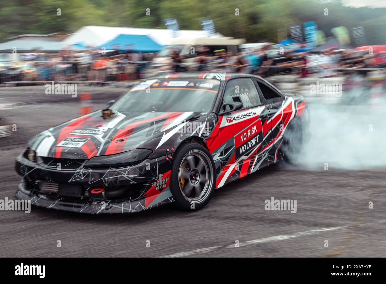 A patterned race Car emitting heavy smoke from the engine during a turn ...