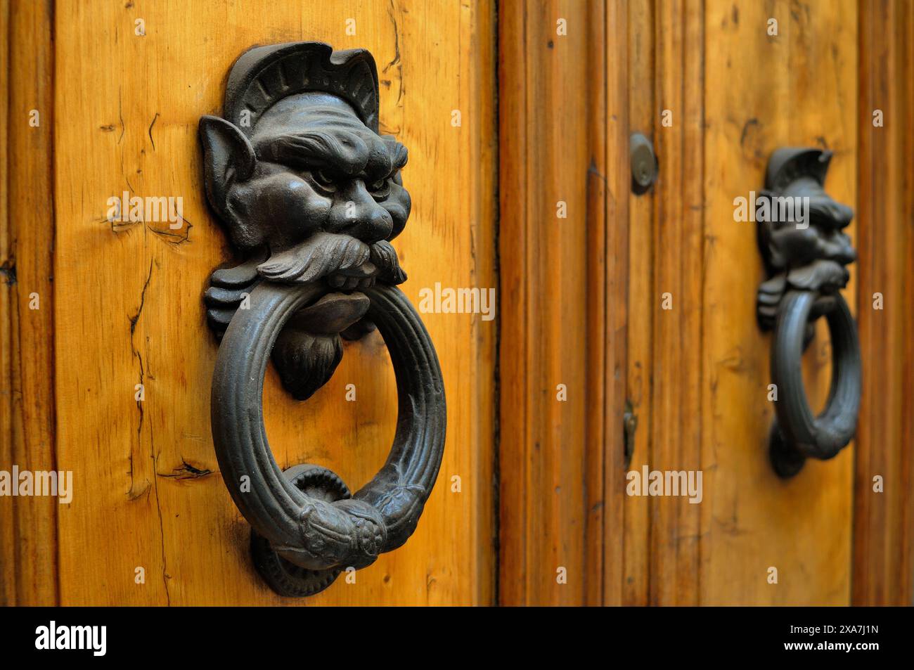 Wooden door handles with human faces on a brown cabinet door Stock ...