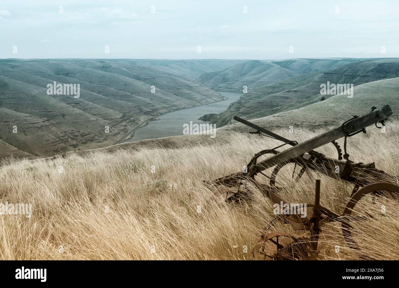 A machine gun in a field setting looking at a landscape featuring a ...