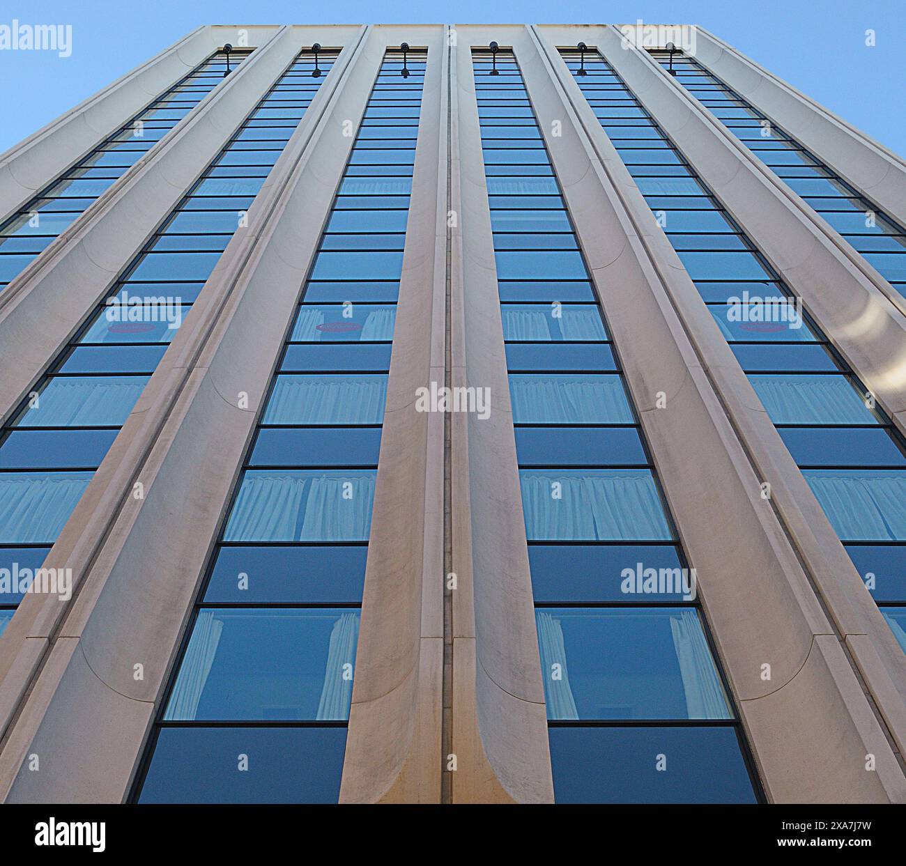 A Tall building with slim blue windows, modern design Stock Photo - Alamy