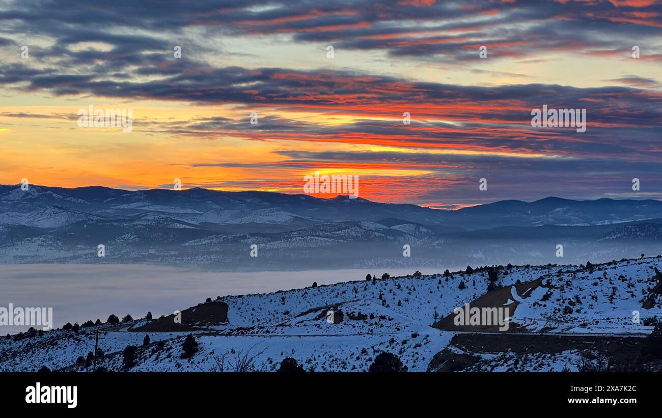 A scenic sunset over snowy mountains and hills Stock Photo - Alamy