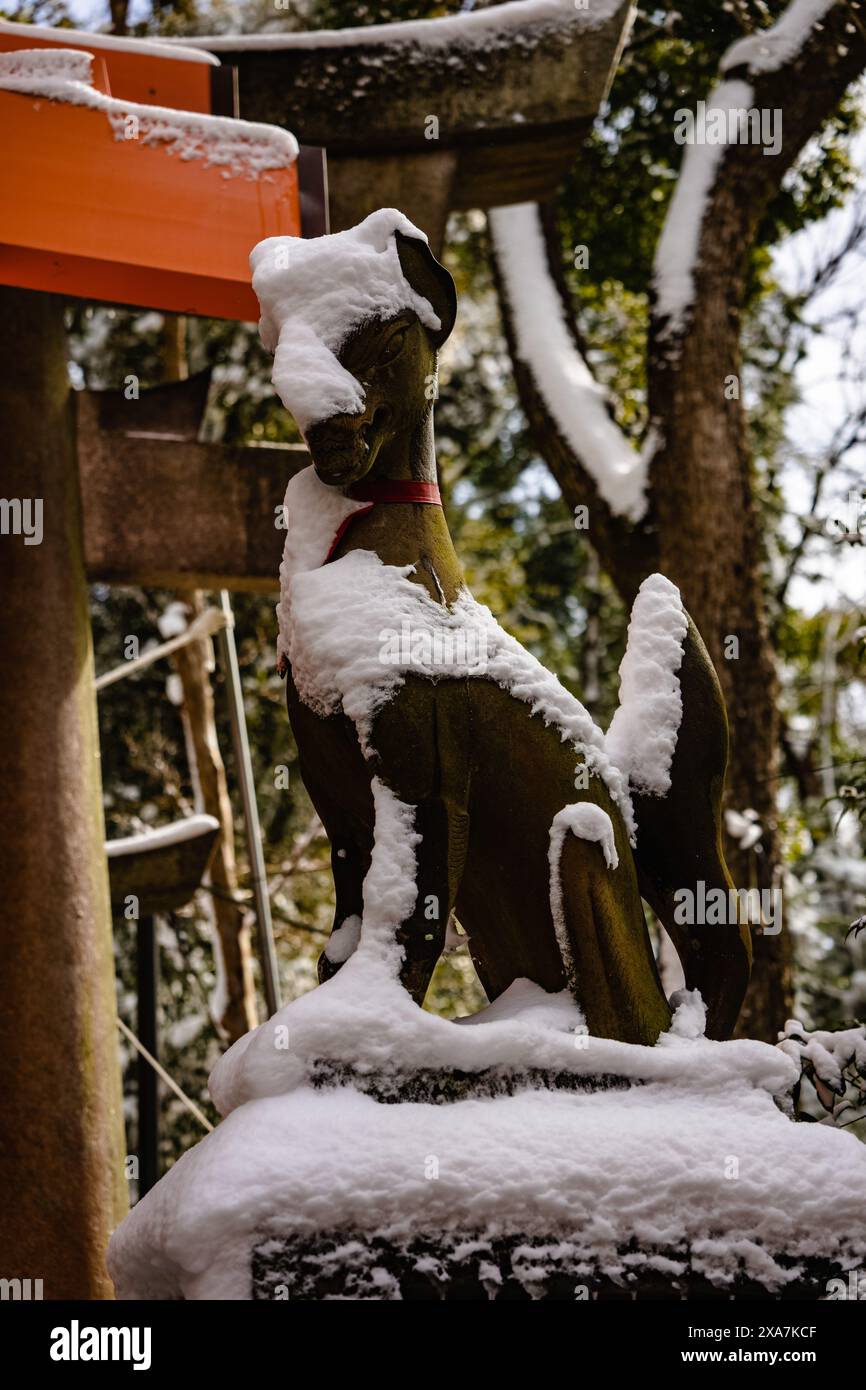 An Ancient style traditional Japanese statue covered in rare winter ...
