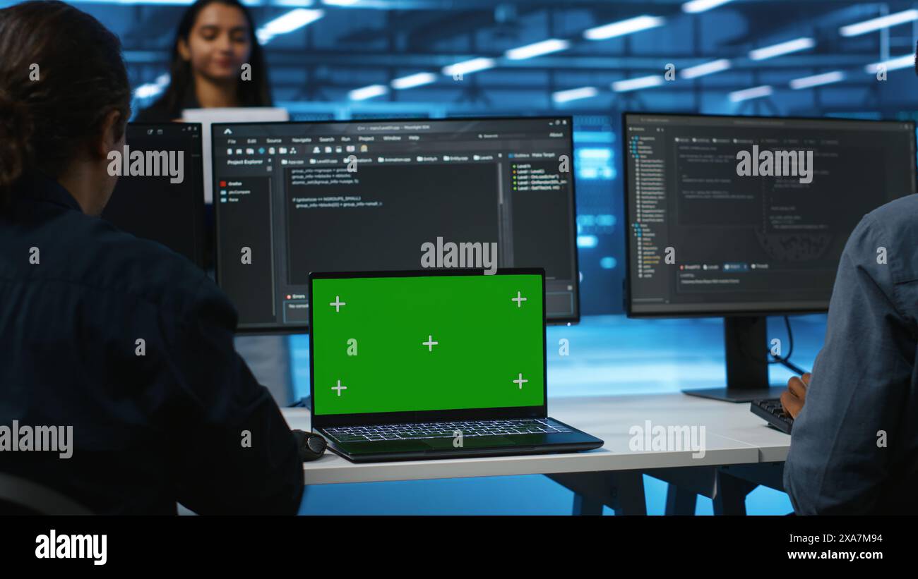 Manager in server hub supervising engineers looking for misconfiguration using isolated screen ...
