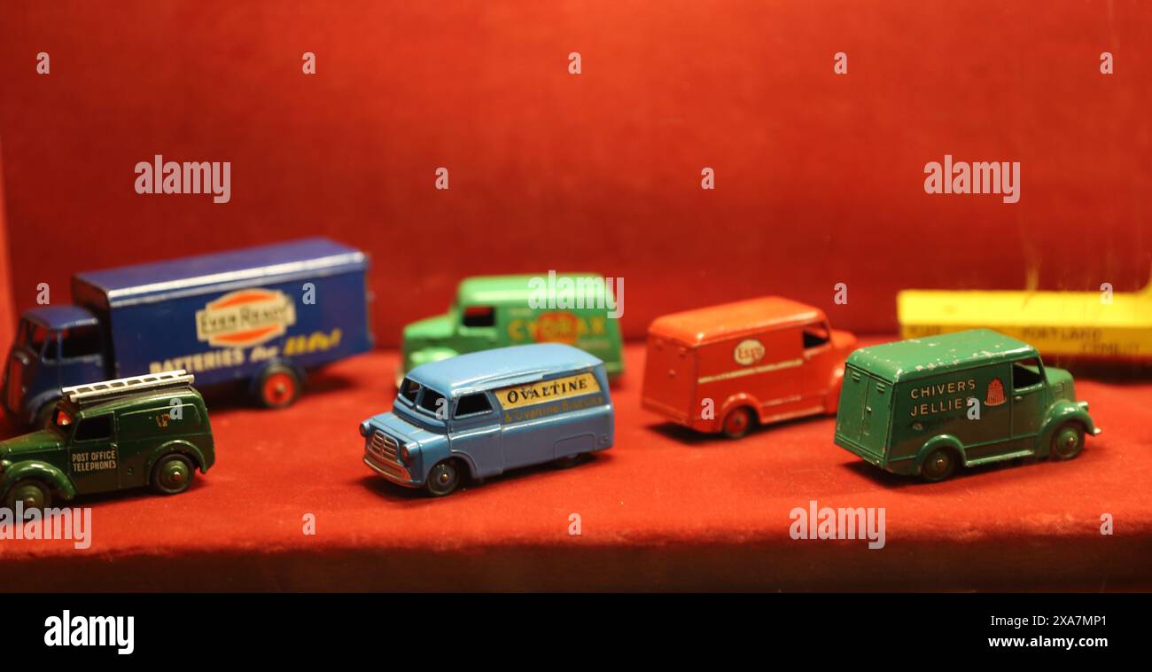The seven diverse plastic toy cars on red background Stock Photo - Alamy
