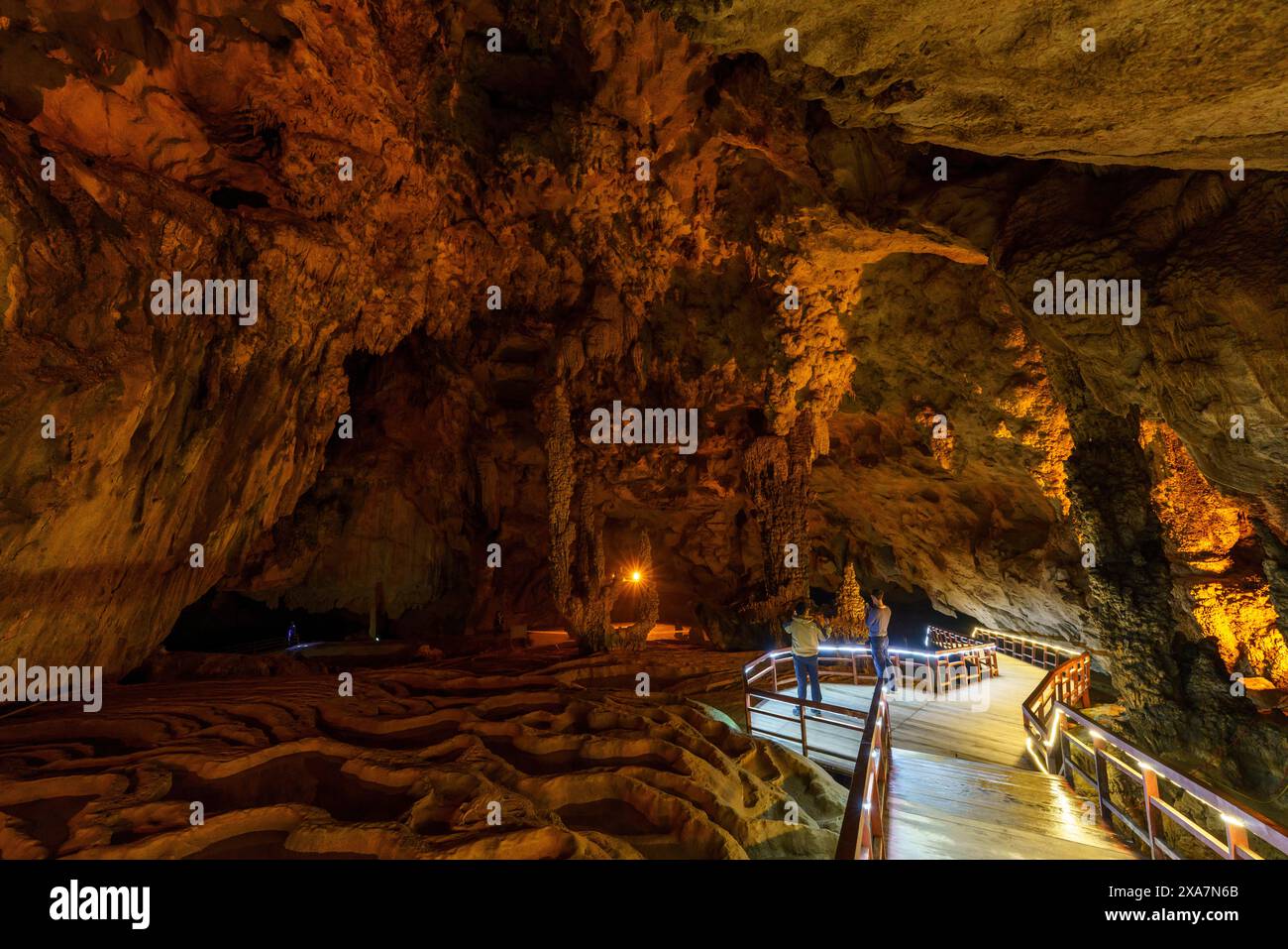 A wooden path extends into a dark mountain cave at night Stock Photo ...