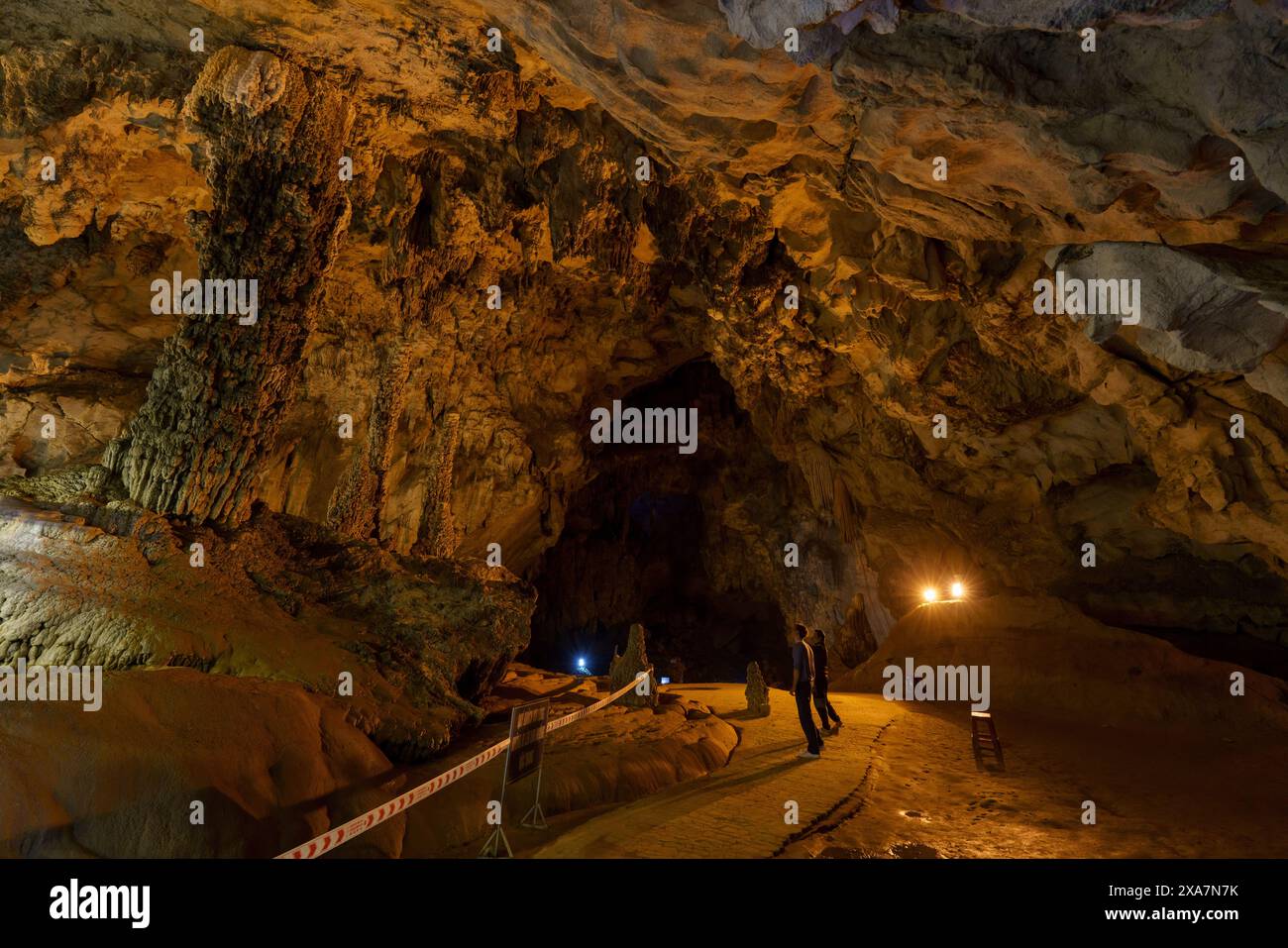 A group of People stand inside of a cave at night, looking at rocky ...