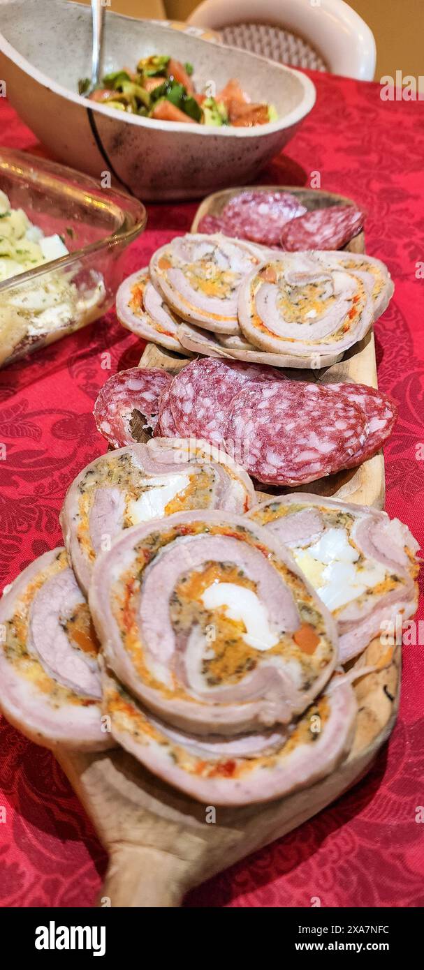 A variety of food items displayed on a table, with leftovers visible ...