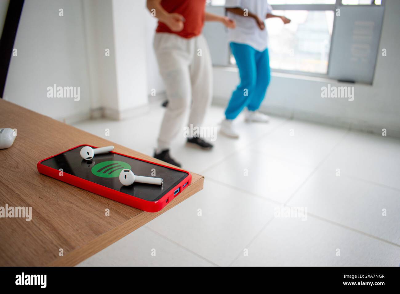 Two men in background, one playing Xbox Wii video game Stock Photo - Alamy