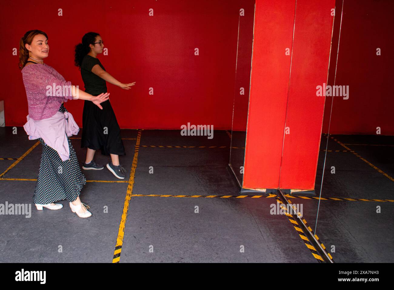 Two women in a garage, one tossing a tool Stock Photo - Alamy