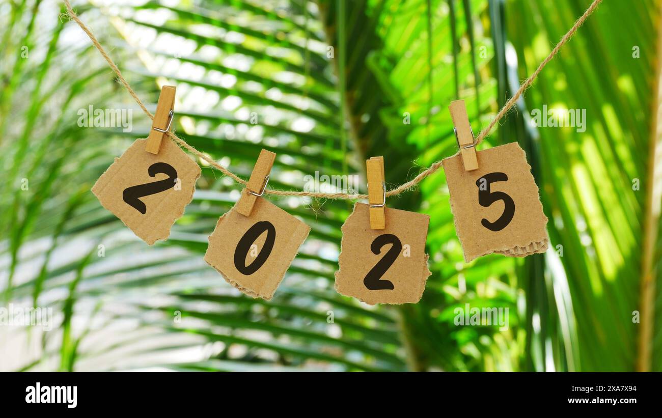 The number 2025 on torn cardboard is stuck and hanging from a string ...