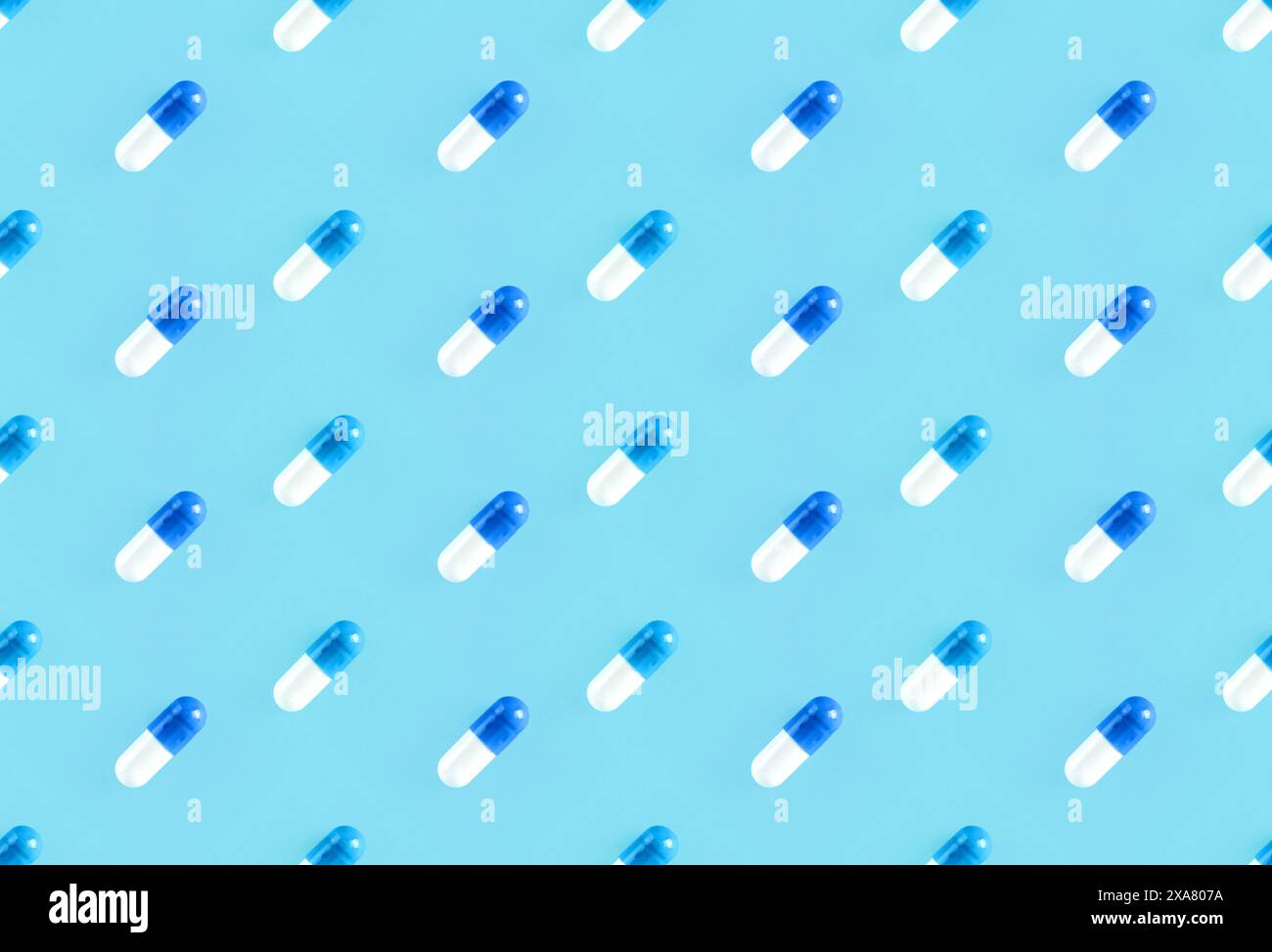 Seamless repetitive two-piece hard starch capsule pills on a soft blue ...