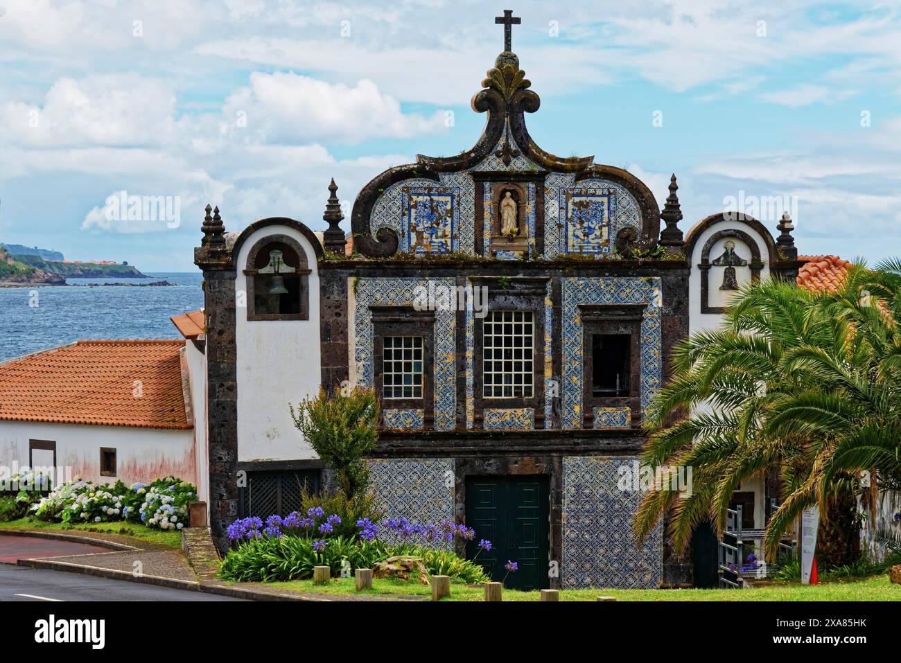 Historic church Convent of Caloura on the coast with blue and white ...
