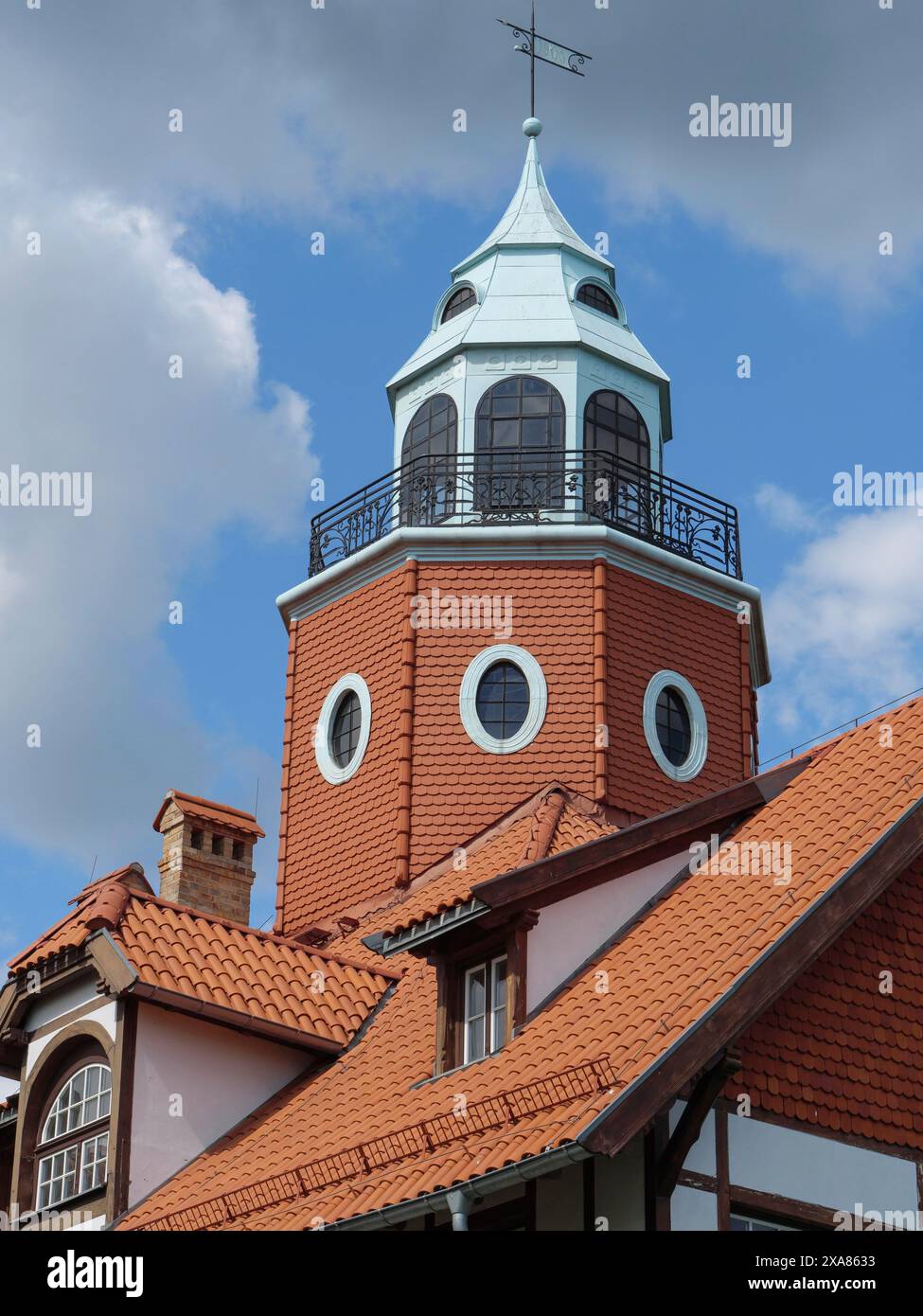 Detailed view of a tower with red bricks, round windows and blue roof ...