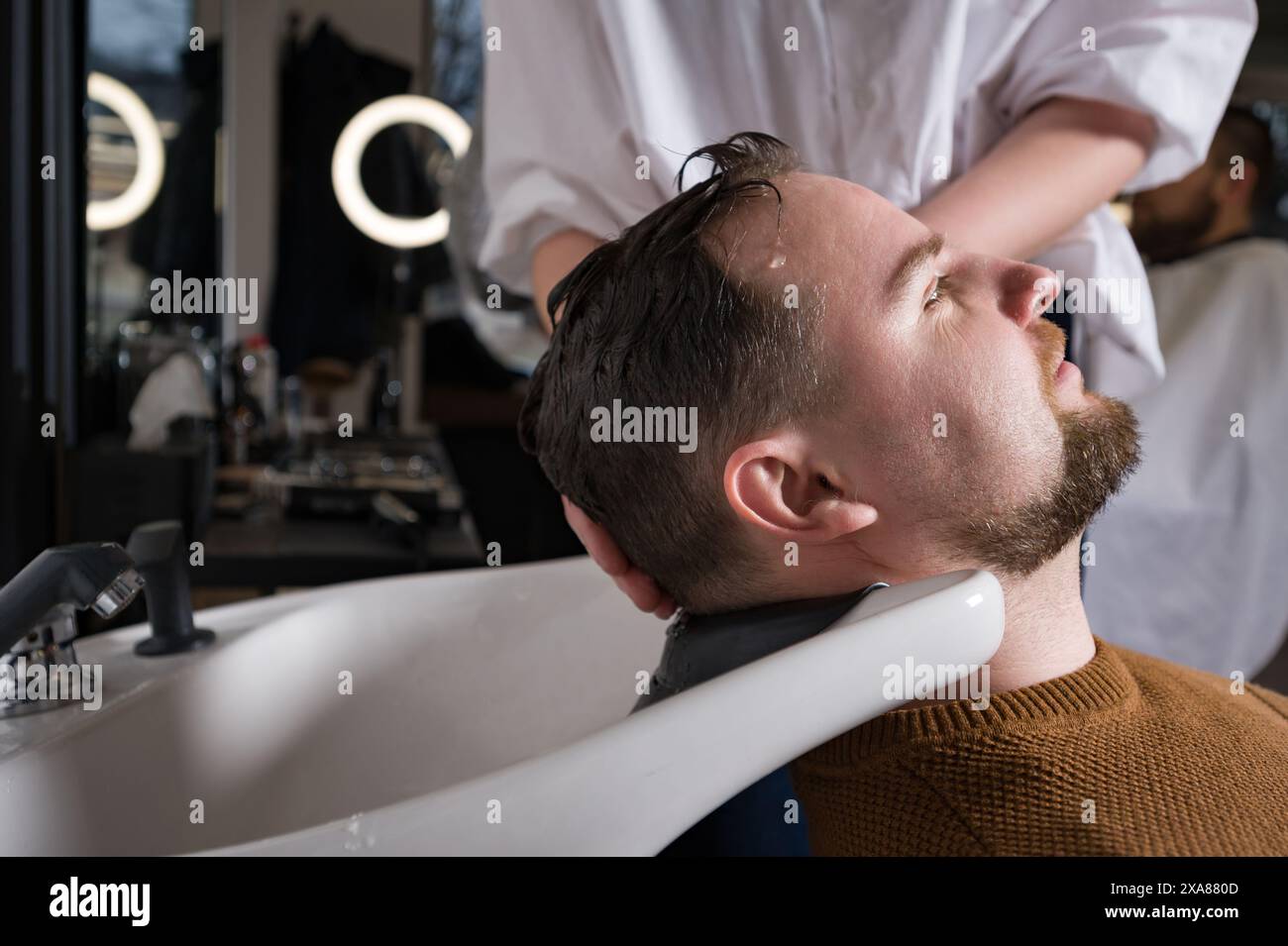 Barber shampooing washing a male client's head in the sink Stock Photo ...