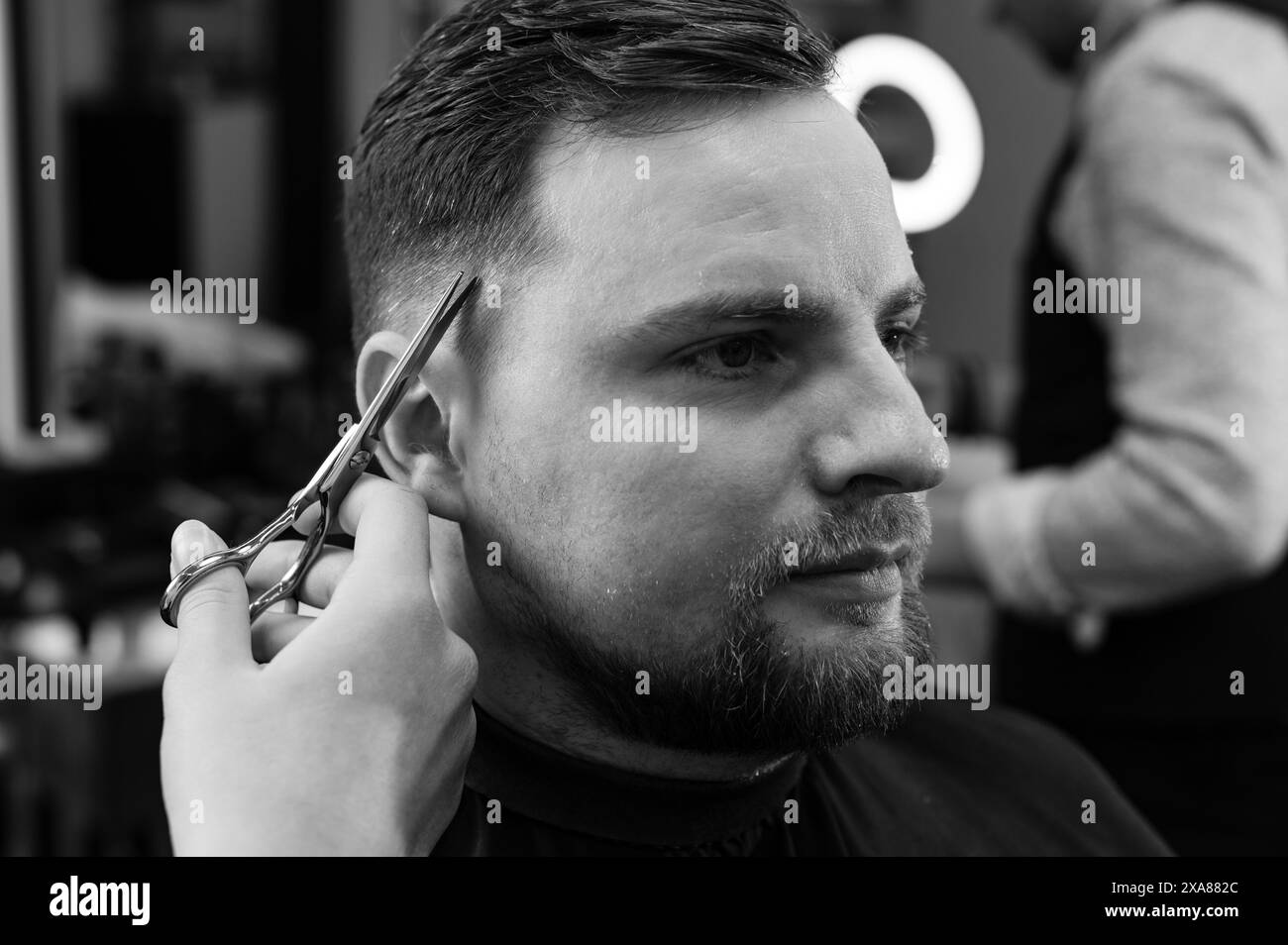 Haircut and alignment of the contour of the head with scissors. Short ...