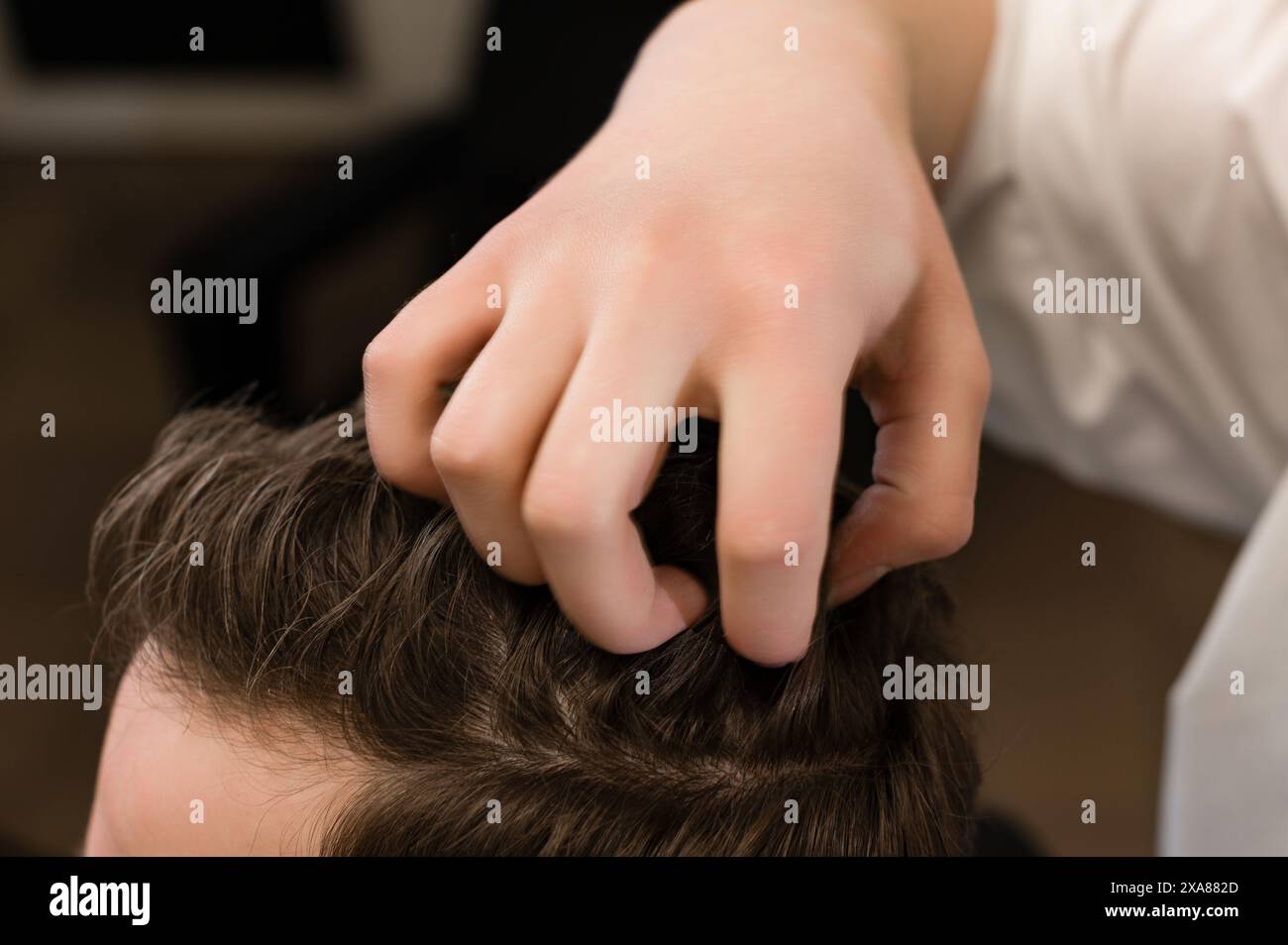 Hair styling with a hand, combing the client's hair by a stylist ...