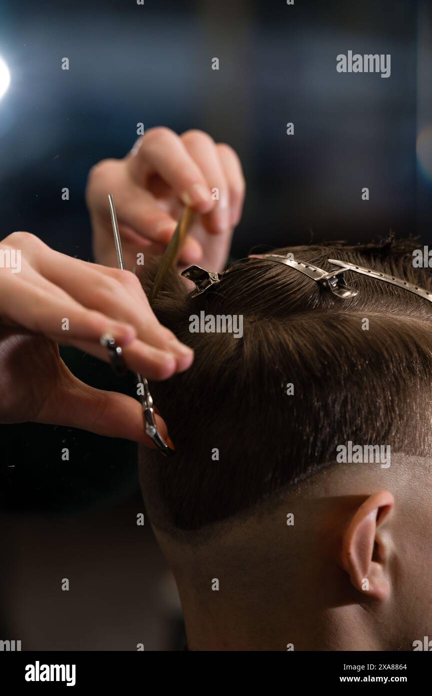 Haircut close up and alignment of the contour of the head with scissors ...