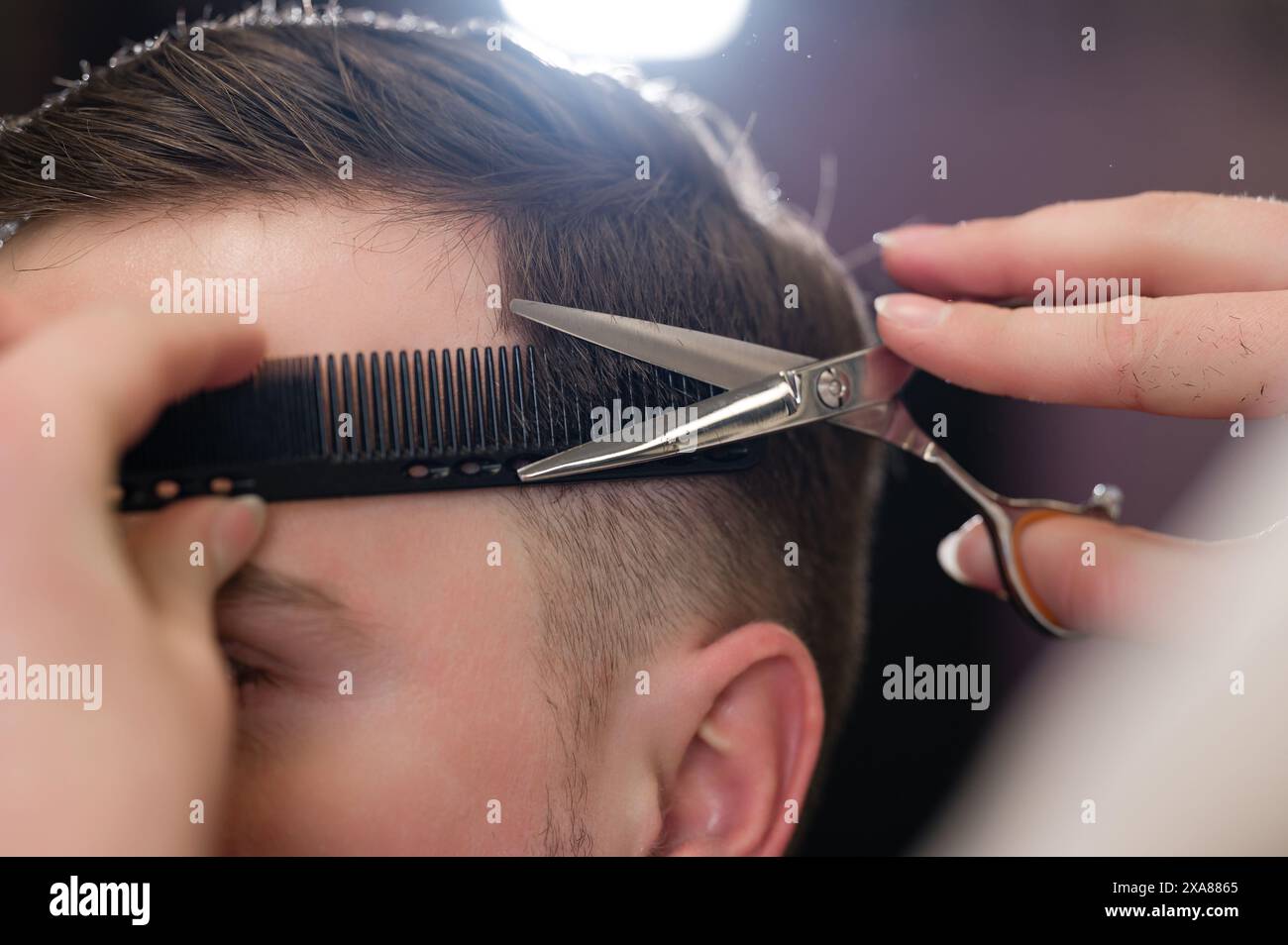 Haircut close up and alignment of the contour of the head with scissors ...