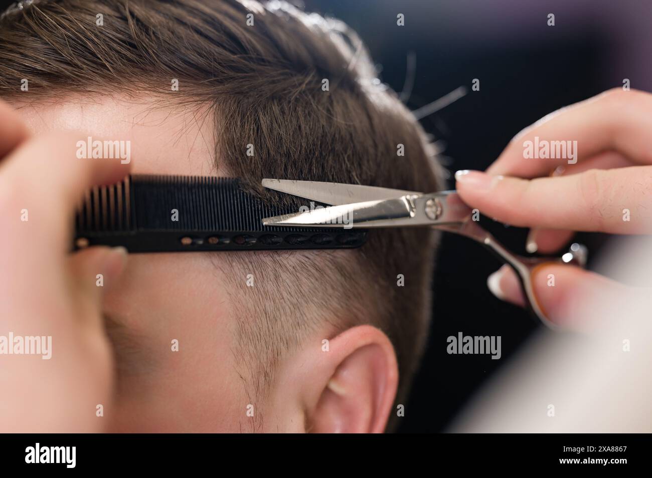 Haircut close up and alignment of the contour of the head with scissors ...