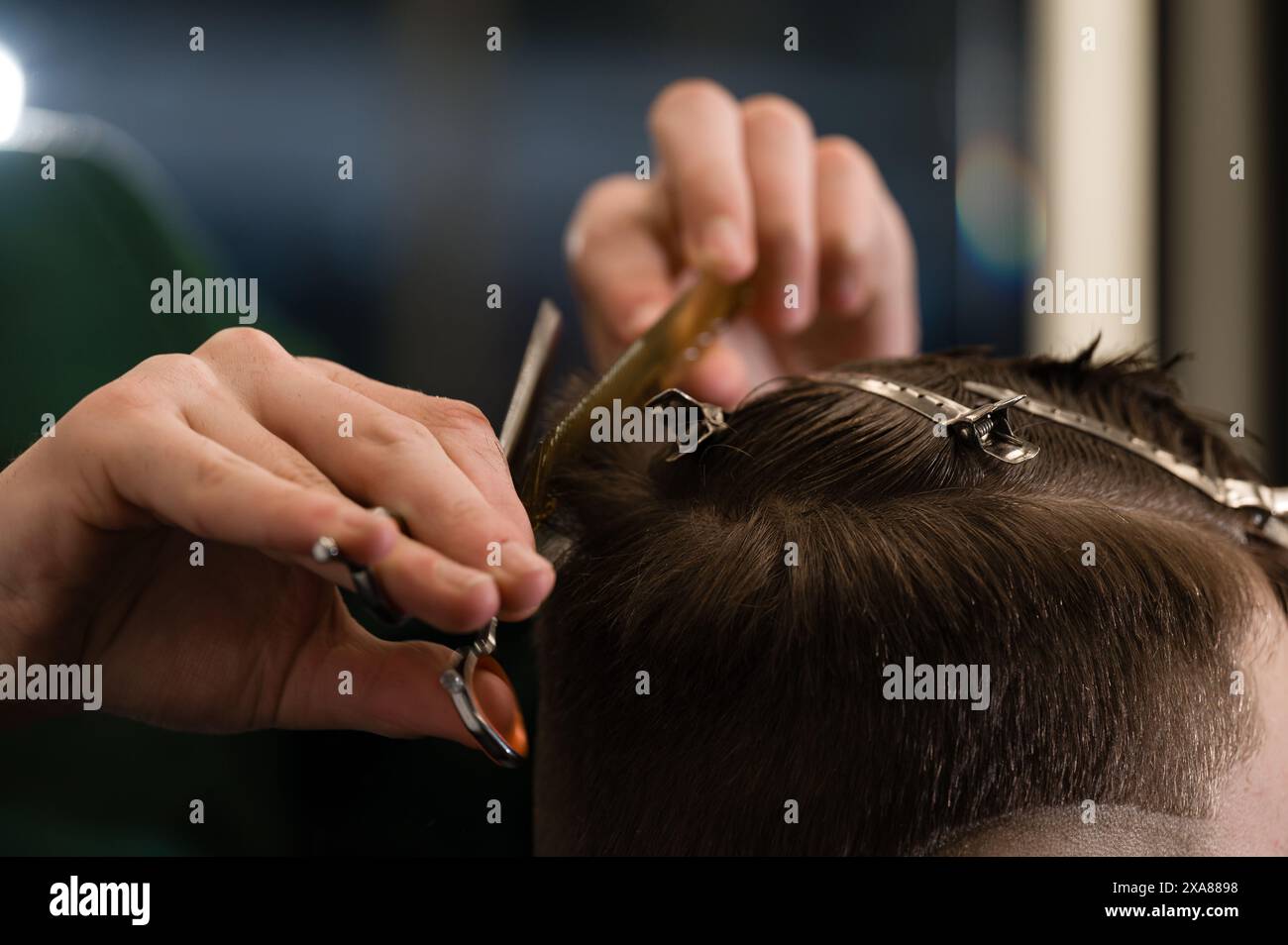 Haircut close up and alignment of the contour of the head with scissors ...