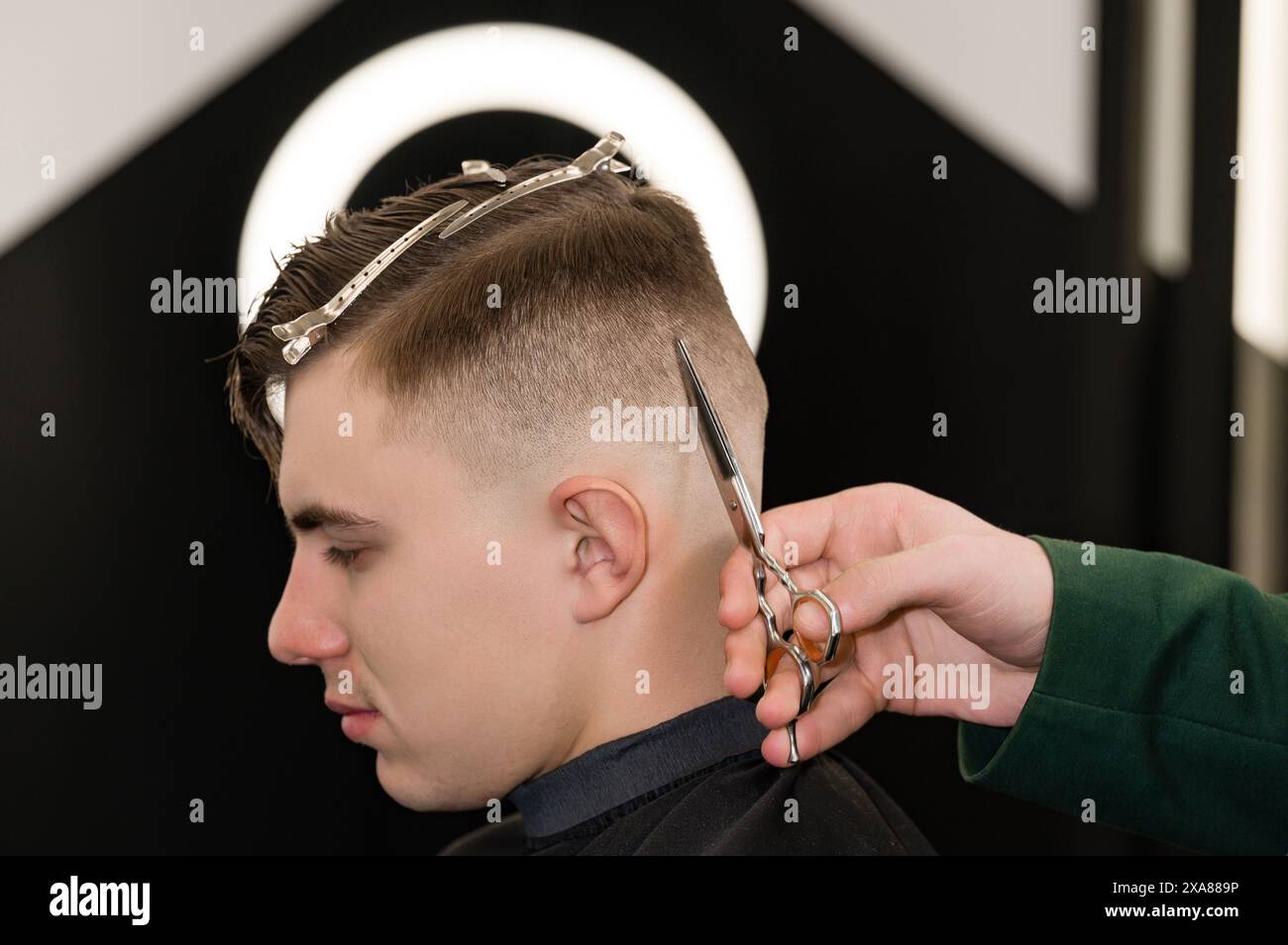 Haircut and alignment of the contour of the head with scissors. Short ...