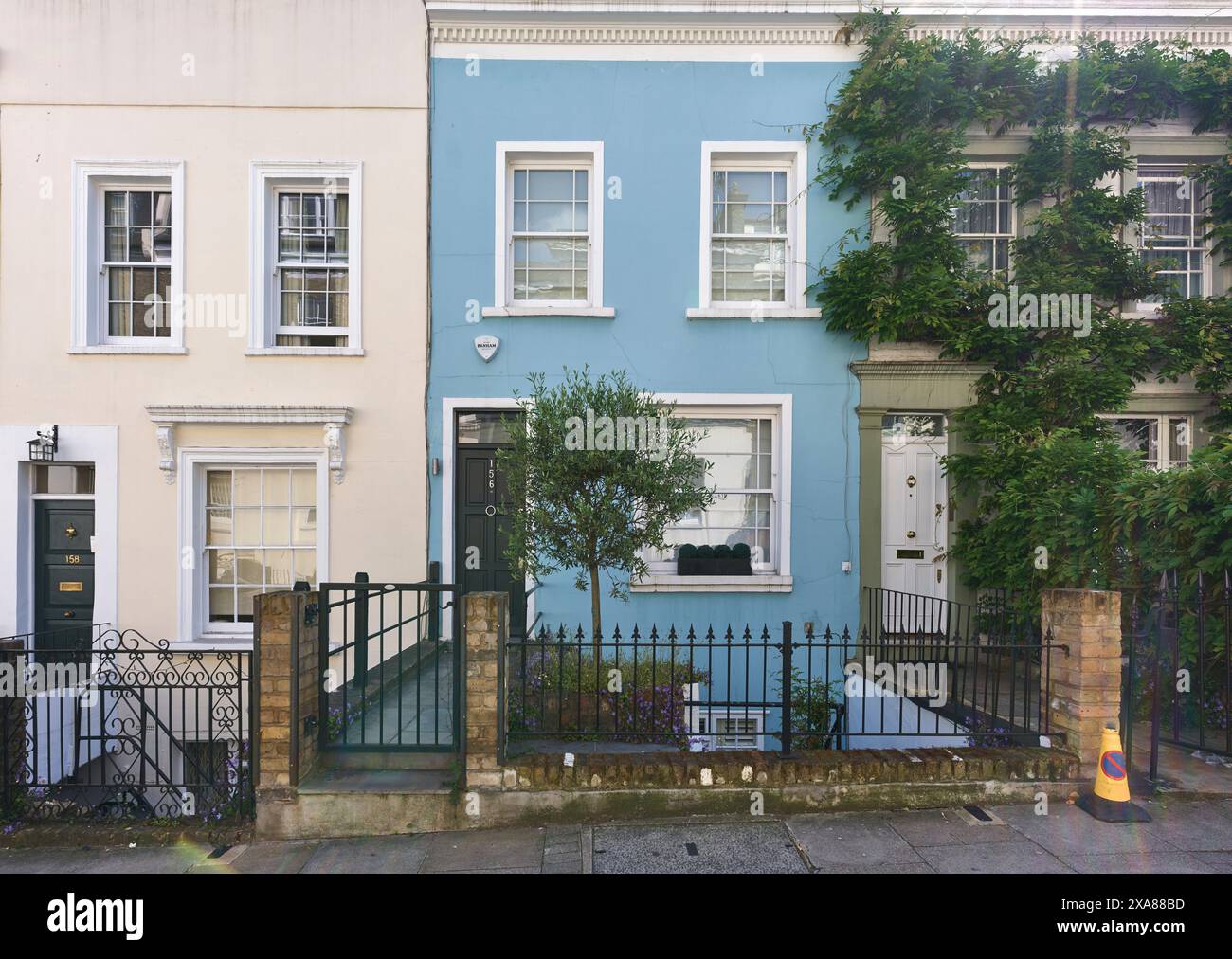 Terraced housing painted in pastel colours on Campden Hill road ...