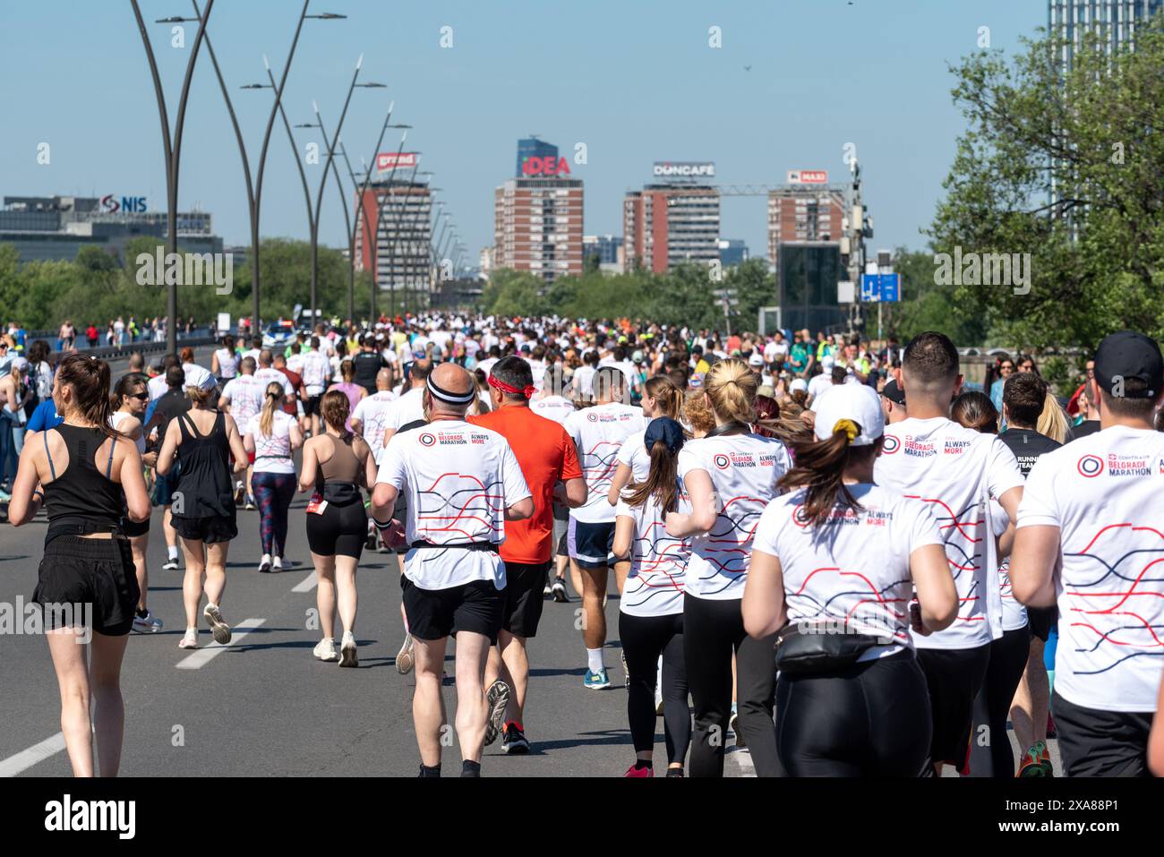 Large group of runners in The 2024 Belgrade marathon running over Branko's bridge towards New ...