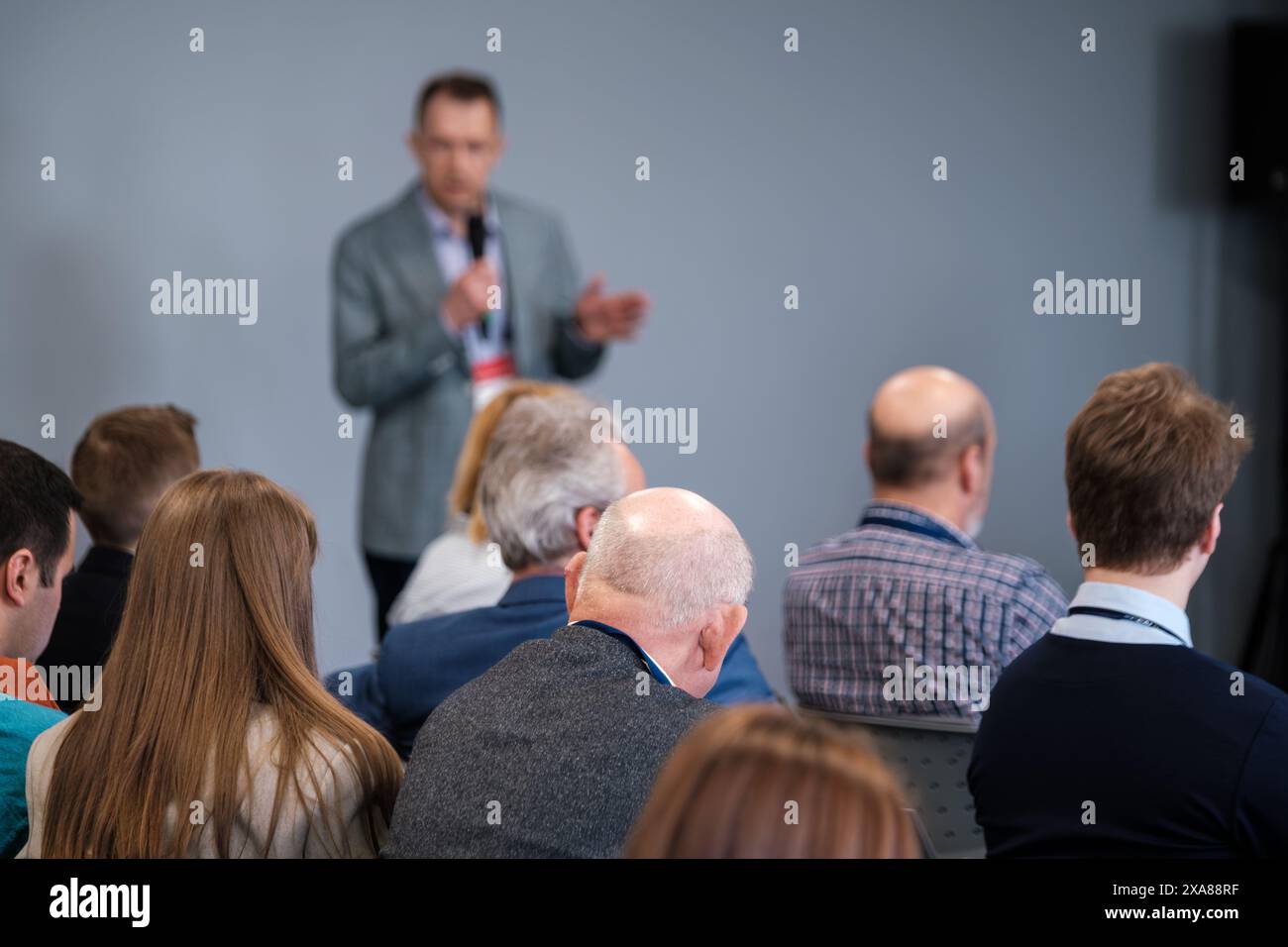 A speaker addressing a diverse audience at a business conference ...