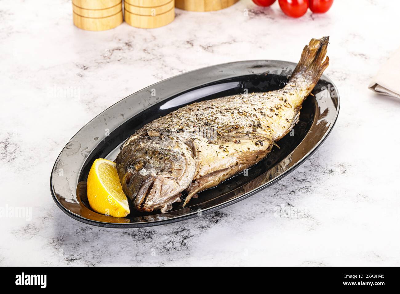 Baked Dorado fish served lemon slice Stock Photo - Alamy