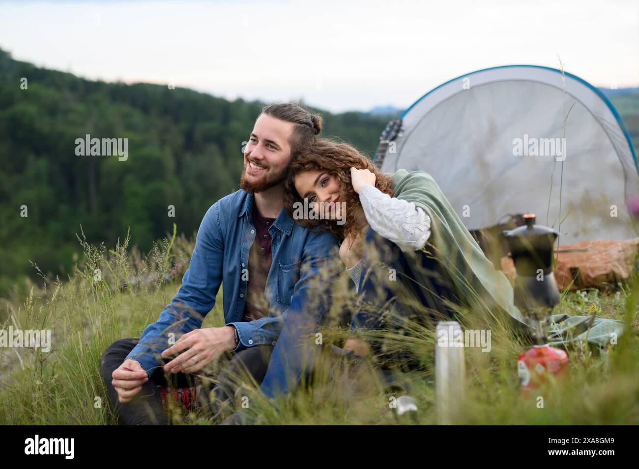 Travellers couple spending time outdoor, sleeping in tent shelter ...