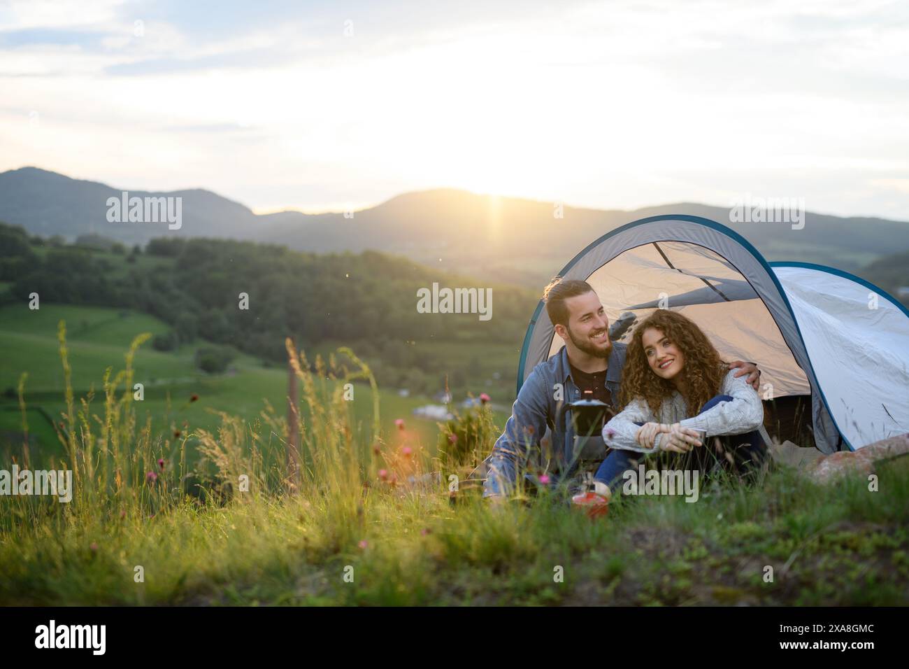 Travellers couple spending time outdoor, sleeping in tent shelter ...