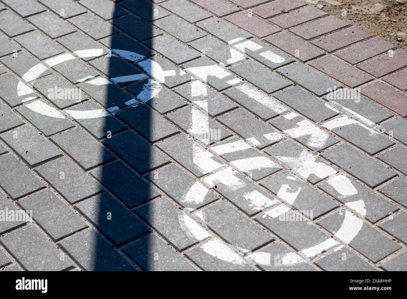 A white bicycle symbol is clearly marked on the grey brick surface of ...