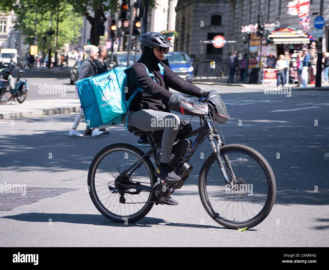 Deliveroo rider on electric bike crossing road in Central London Stock ...