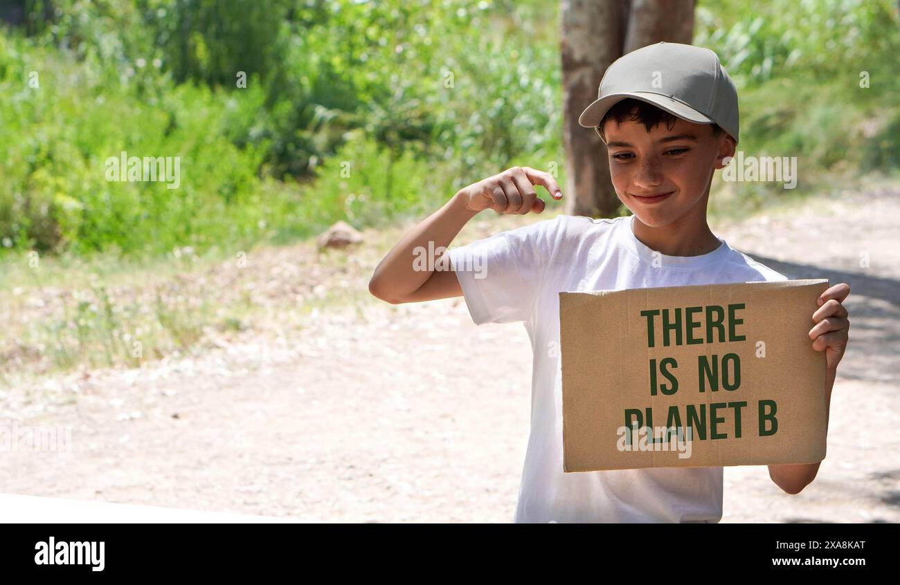 preadolescent boy in nature showing a sign that says ‘there is no ...