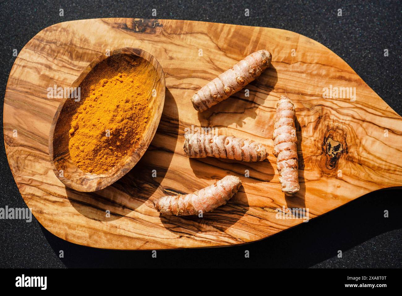turmeric (Curcuma longa), Rhizome pieces and wooden bowl with turmeric ...