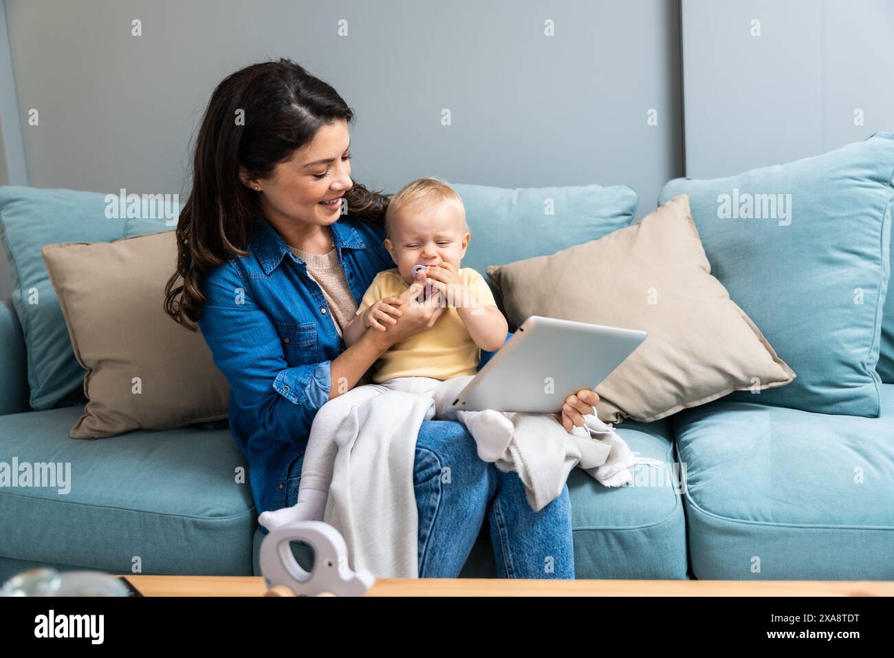Happy family mom and kid daughter using digital tablet sitting on sofa ...