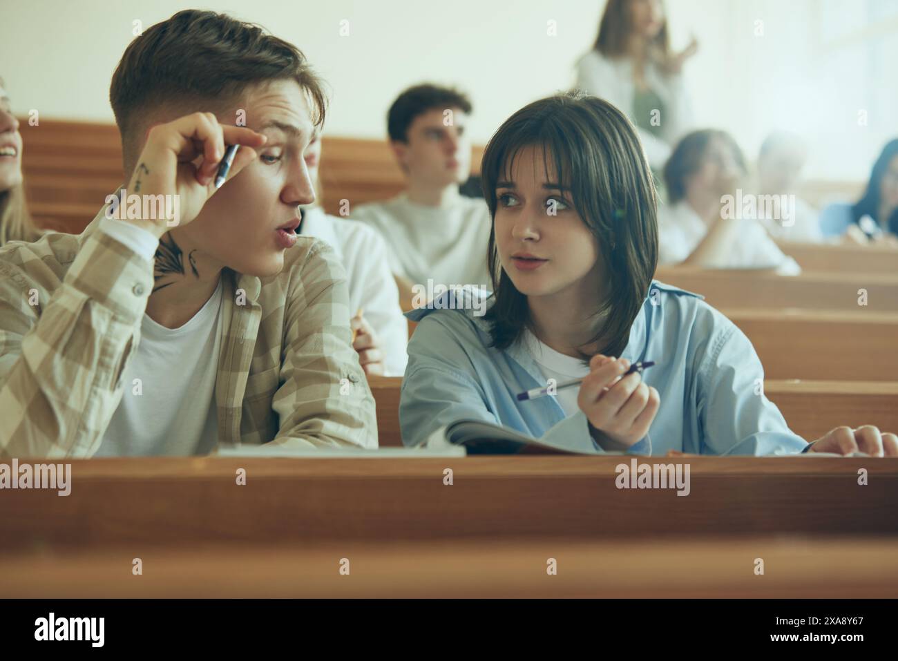 Young boy and girl, classmates sitting in university classroom and ...