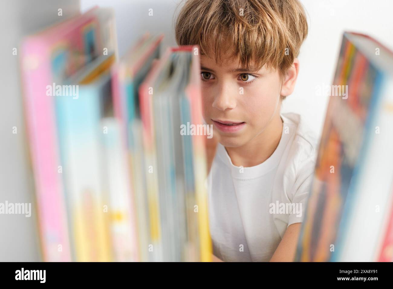 Boy choosing book from library hi-res stock photography and images - Alamy