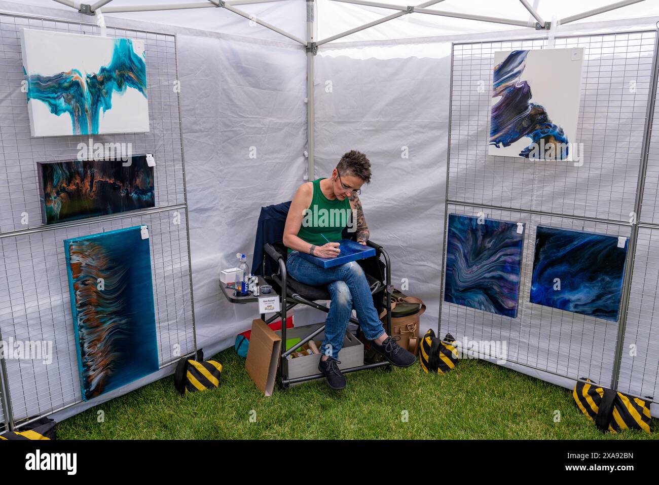 An artist works on a painting at the annual Moab Arts Festival in Moab ...