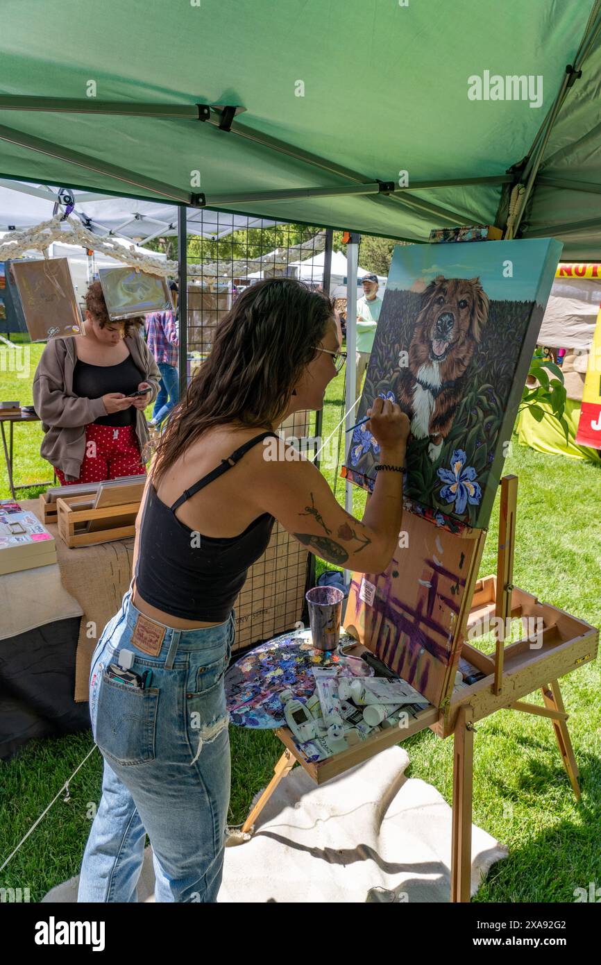An artist works on a painting at the annual Moab Arts Festival in Moab ...