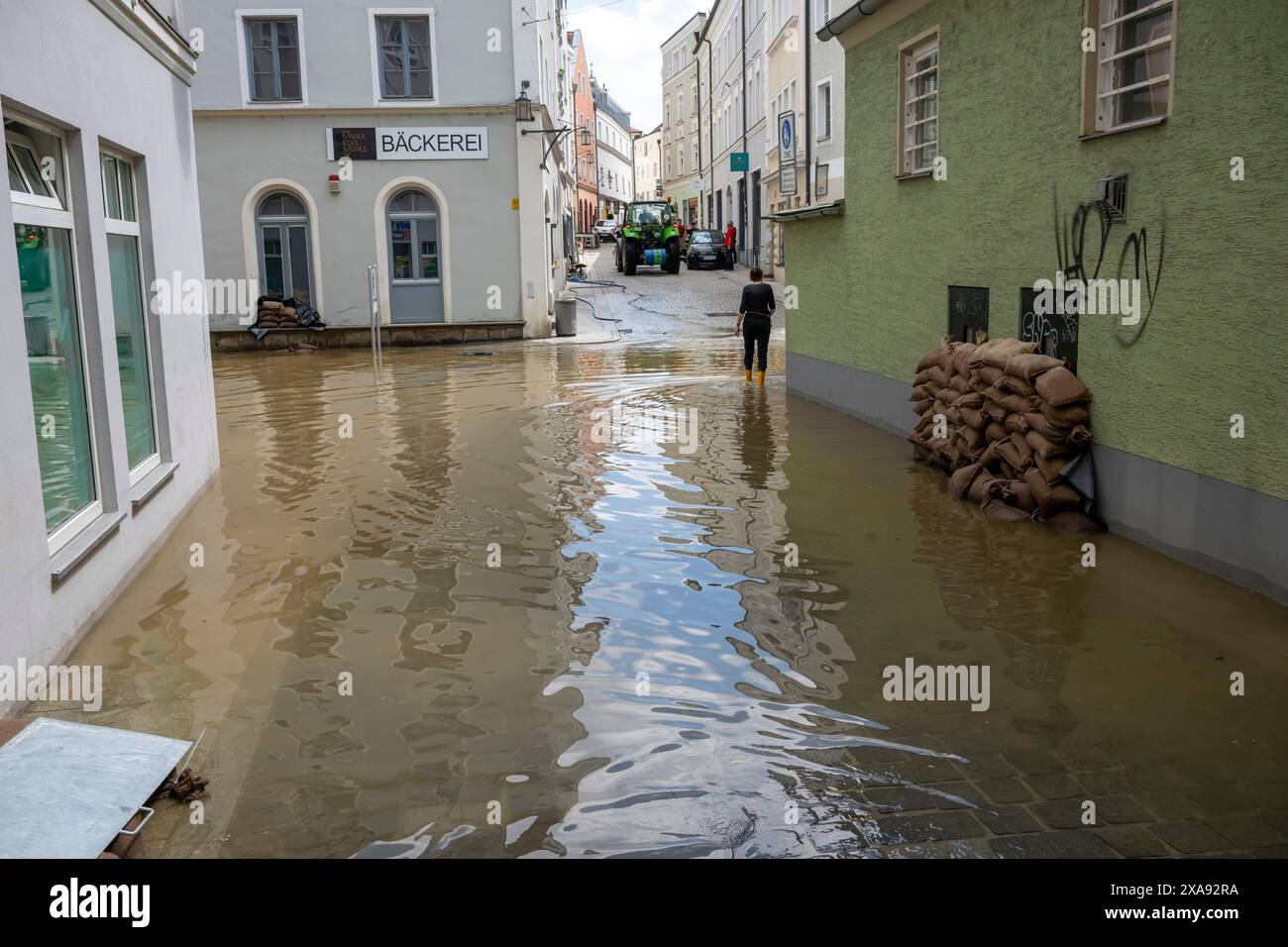 Passau, Germany. 05th June, 2024. A woman walks through a flooded alley ...