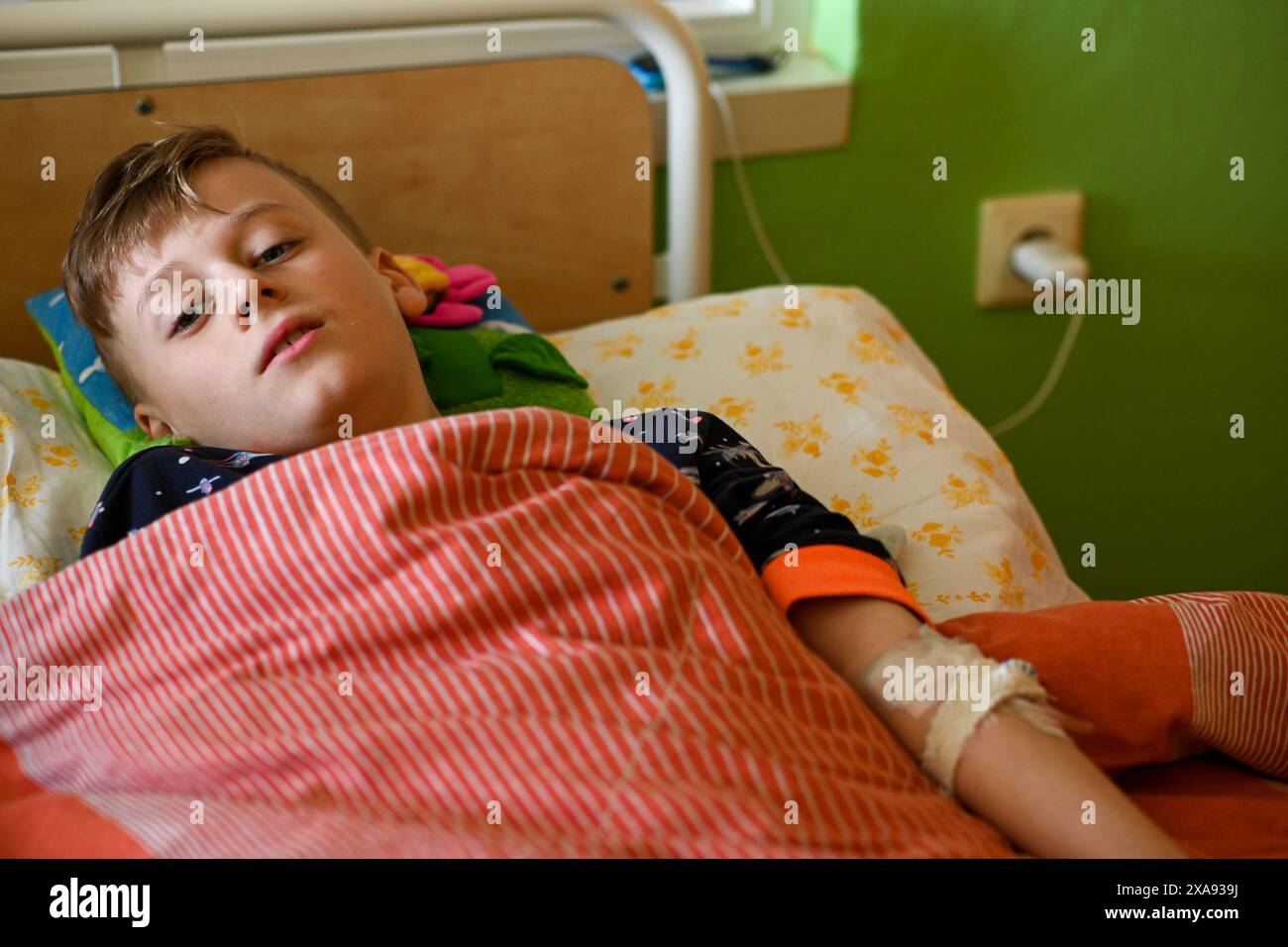 Sick child resting in a hospital room with an iv drip in his arm ...