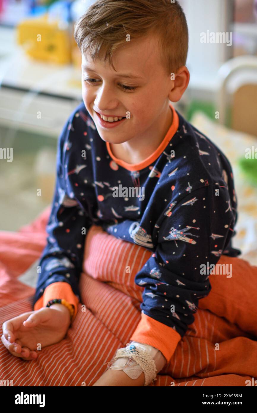 Sick child resting in a hospital room with an iv drip in his arm ...