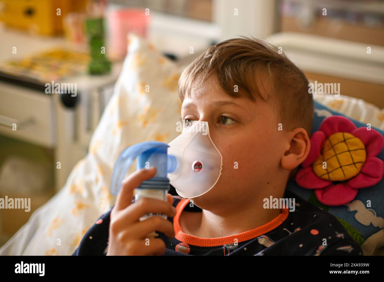 Child patient takes medication via an inhaler while sitting in a ...