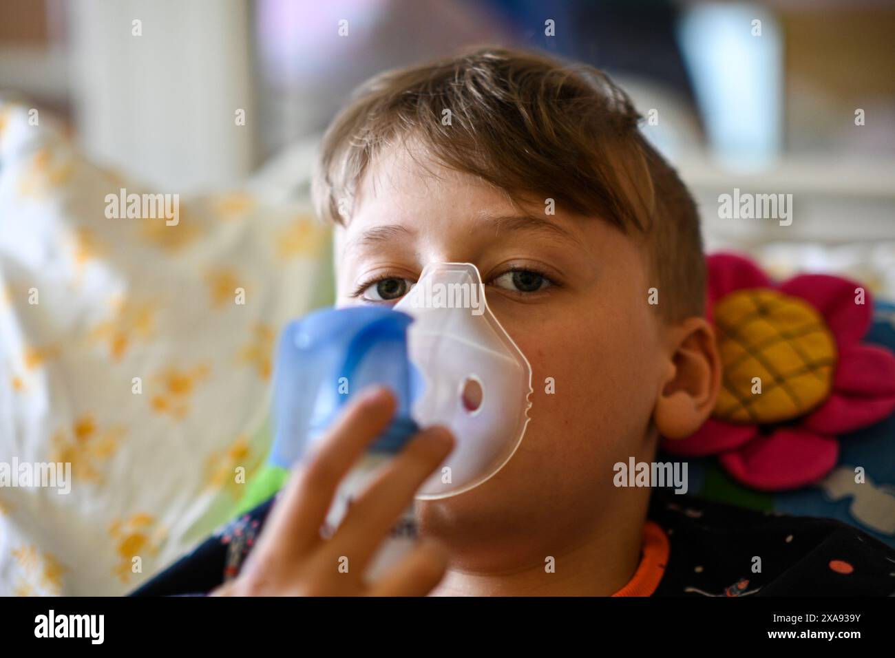 Child patient takes medication via an inhaler while sitting in a ...